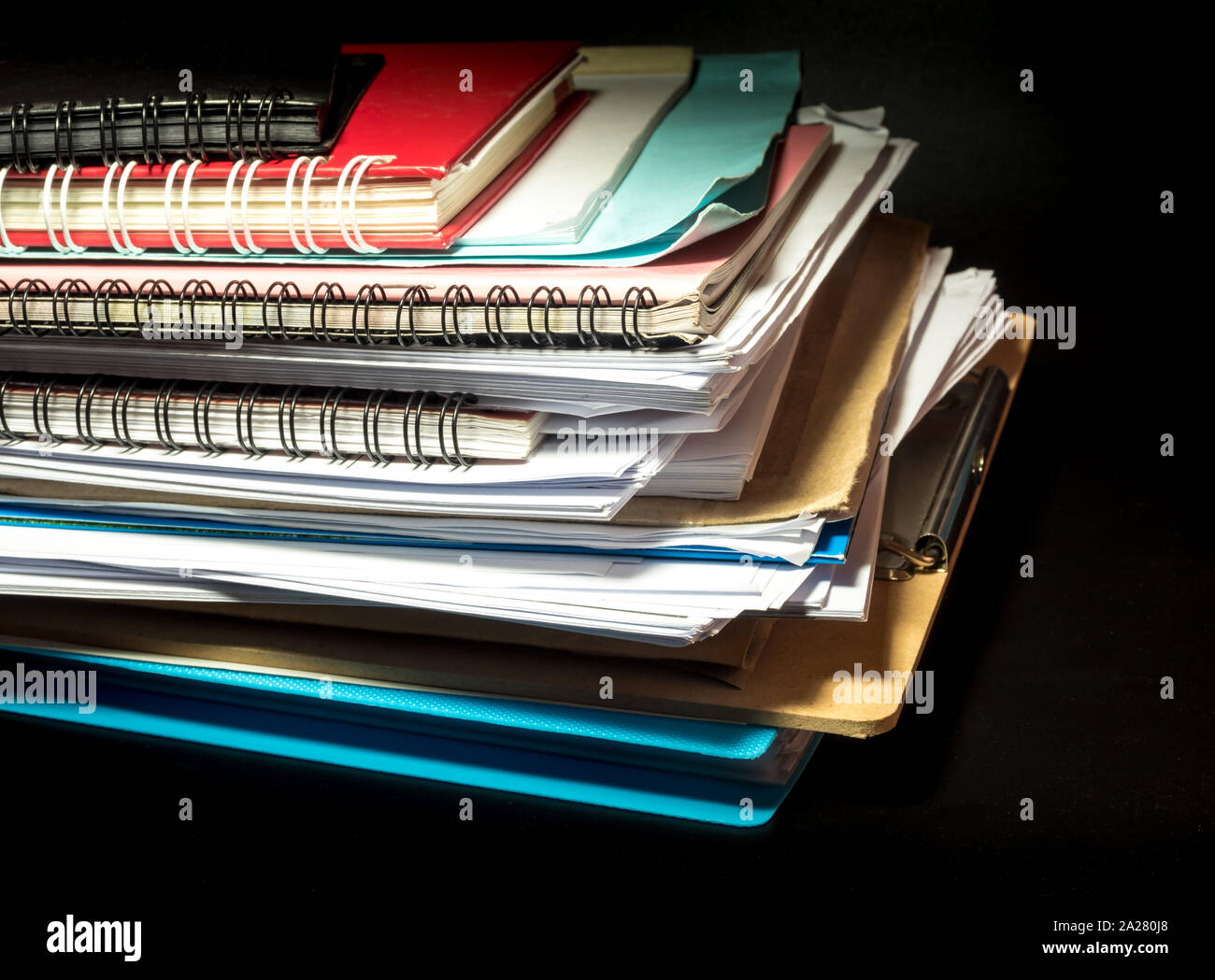 Stacked of office documents paper and notebook in the black background ...