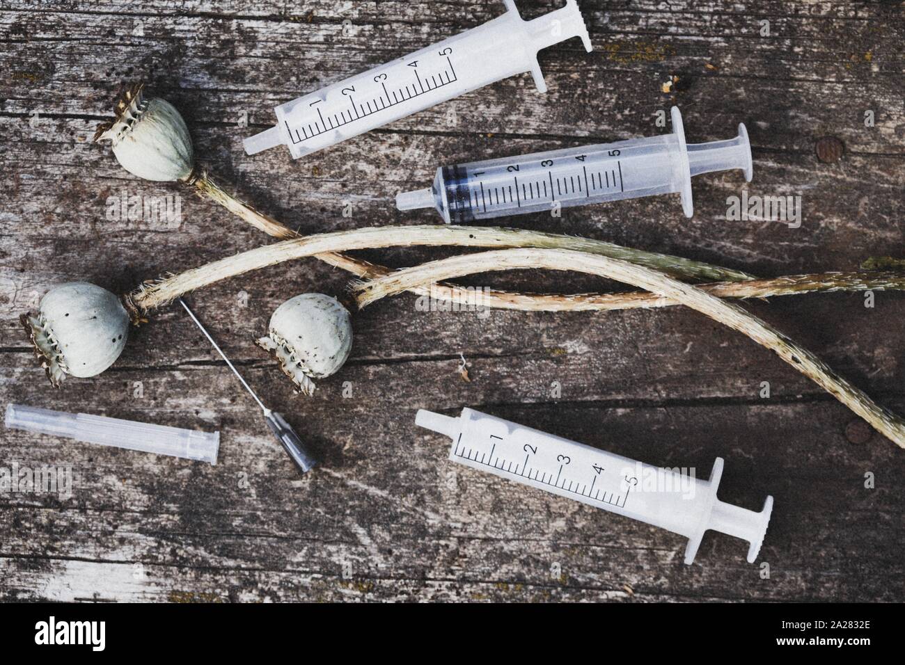 opium poppy seeds and syringes with Needles on wooden background ...