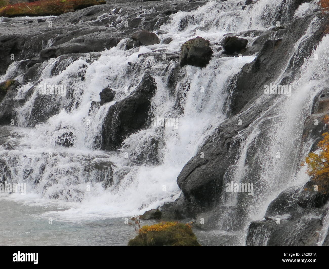 Tumbling torrents of water over the volcanic rocks at Hraunfossar ...