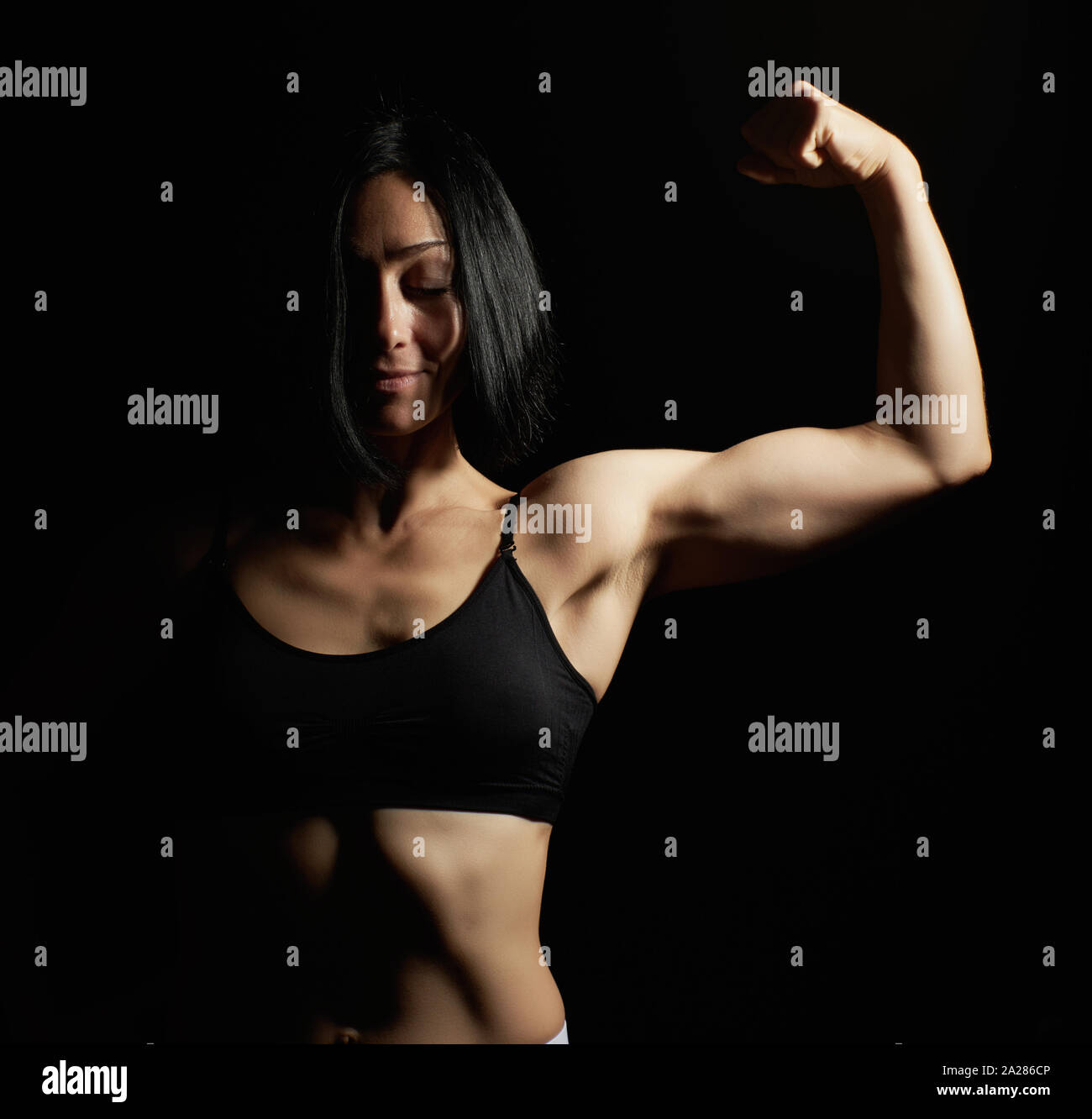 young beautiful athletic girl raised and bent her arm demonstrating her ...