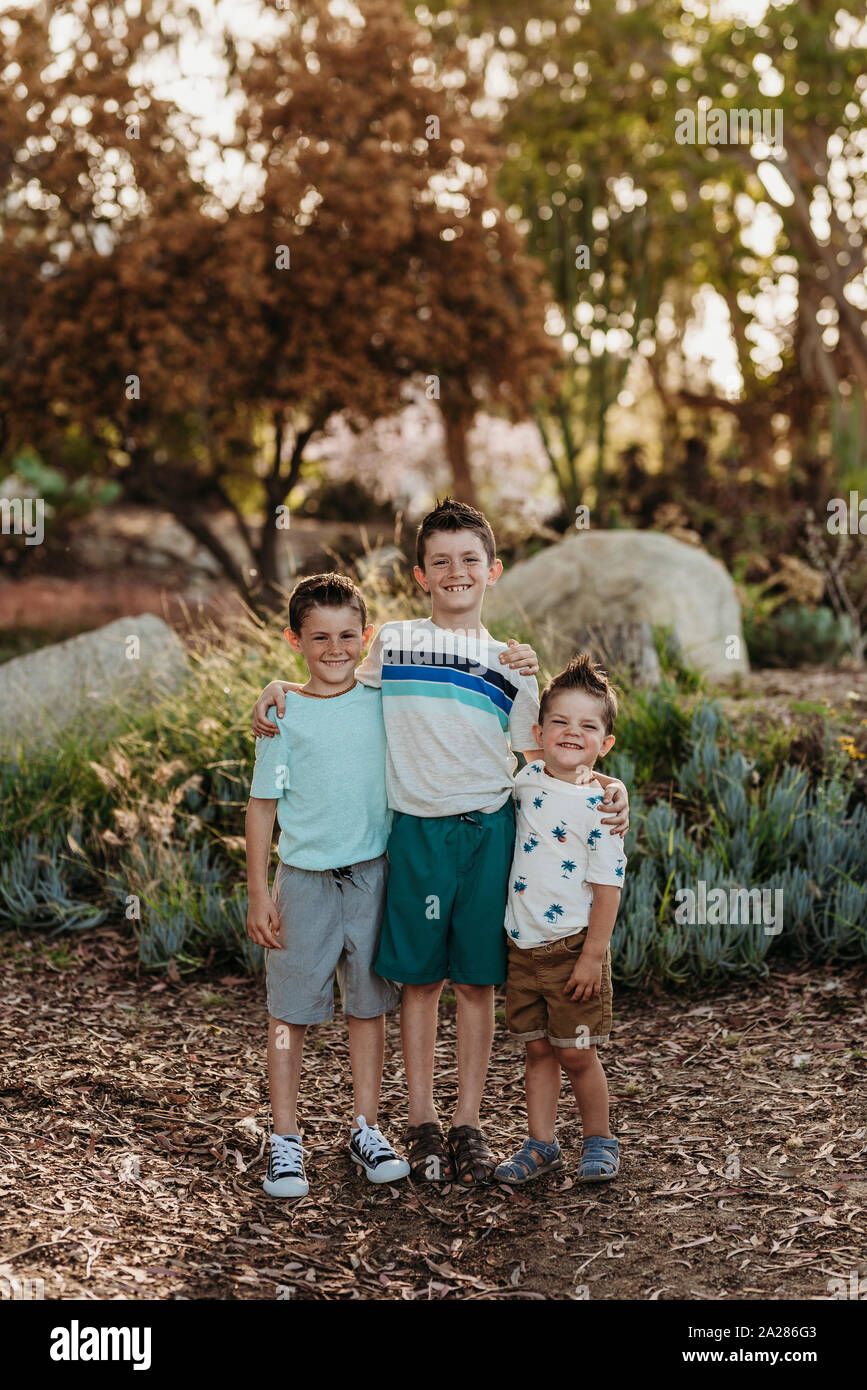 Portrait of three brothers smiling at camera in cactus garden Stock ...