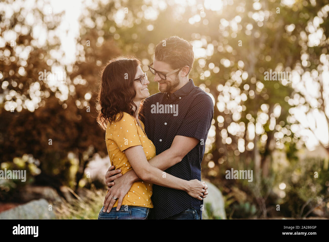 Portrait Of Husband And Wife Smiling At Each Other And Hugging Stock