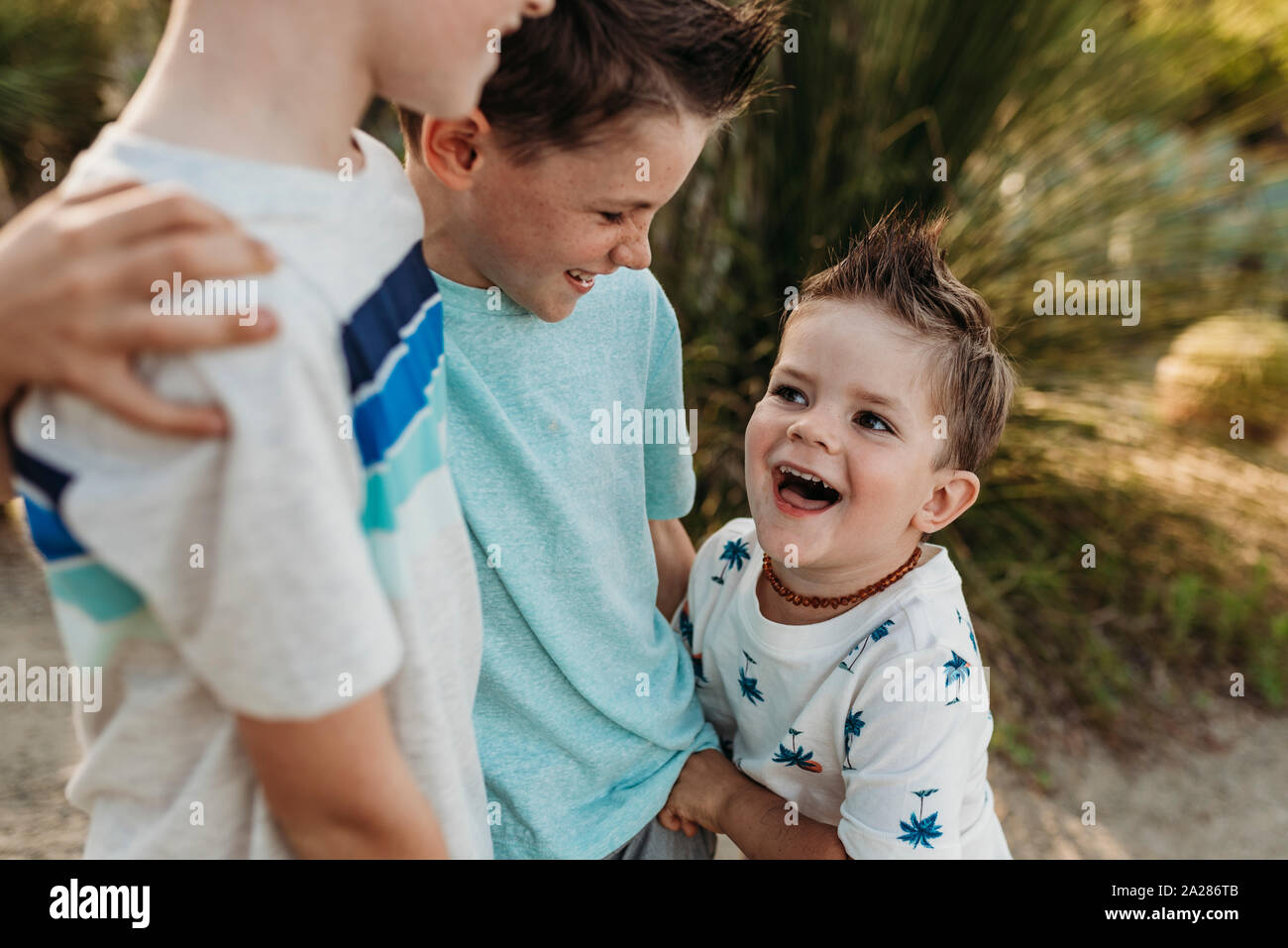 Close up of three brothers looking at each other while smiling Stock ...