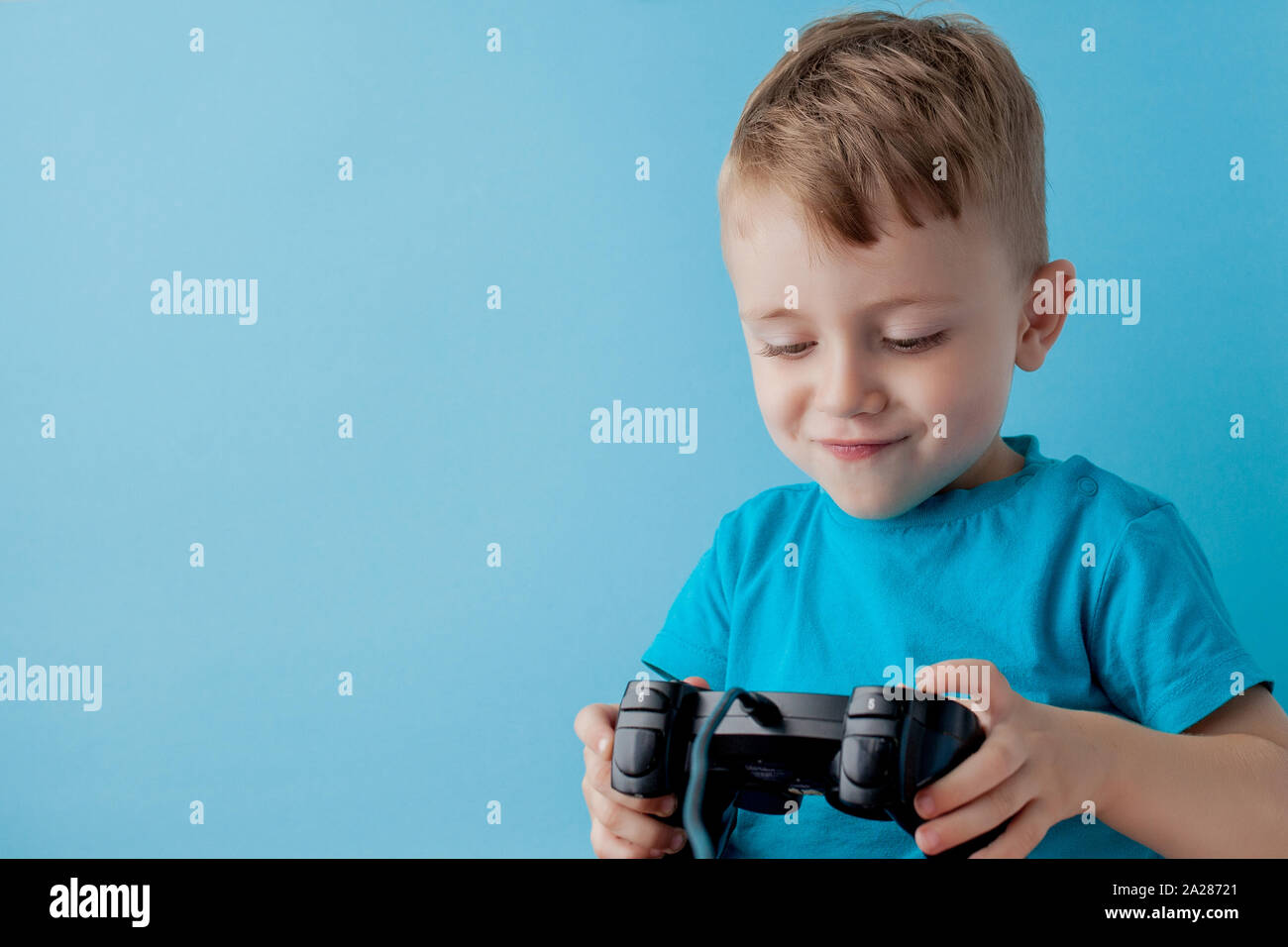 Little kid boy 2-3 years old wearing blue clothes hold in hand joystick ...