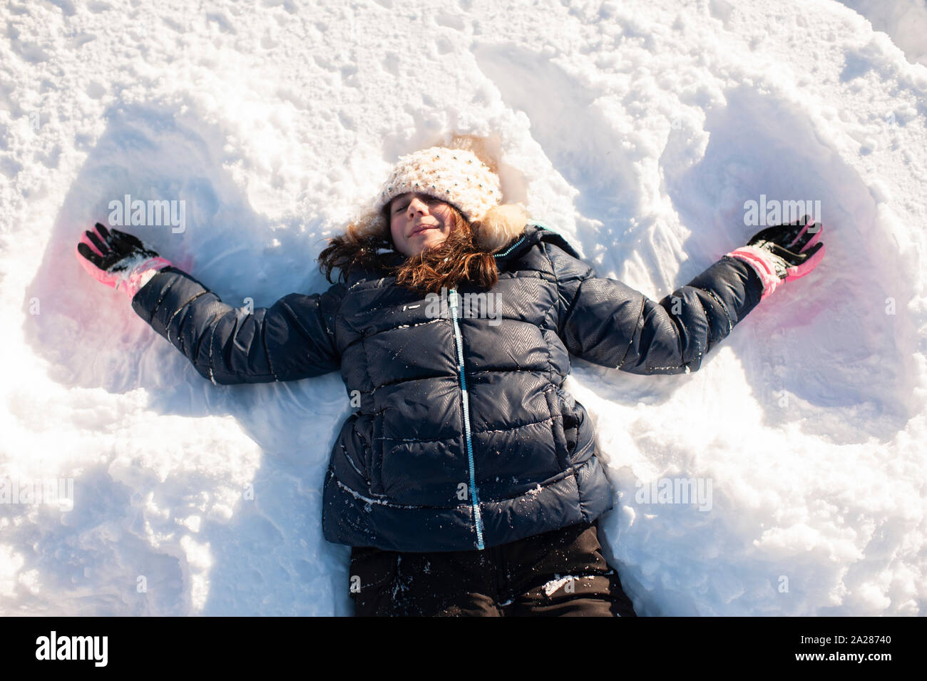 Overhead view of tween girl making snow angel in the front yard Stock ...