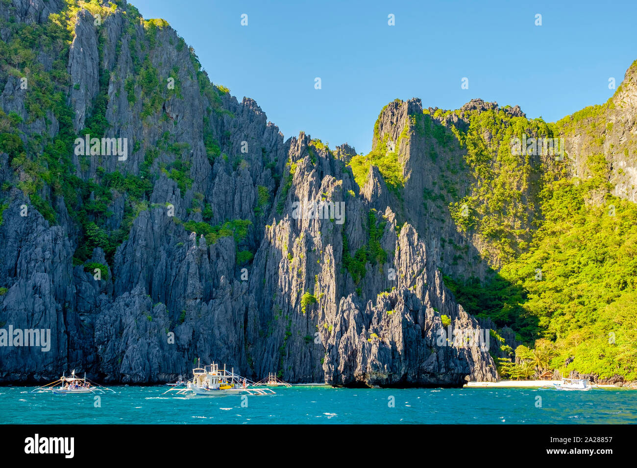 Dramatic karst limestone cliffs at Secret Lagoon Beach on Miniloc ...