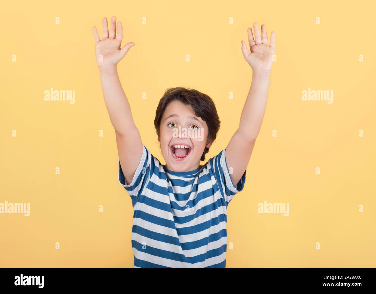happy child raising hands up on yellow background Stock Photo - Alamy