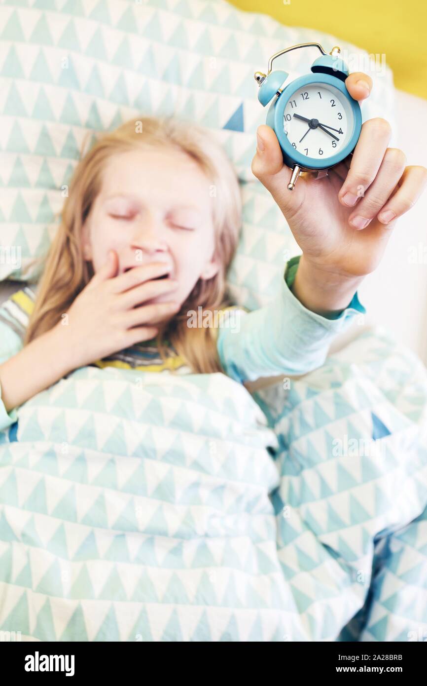 alarm clock disturbing a sleeping little girl that is defocused Stock ...