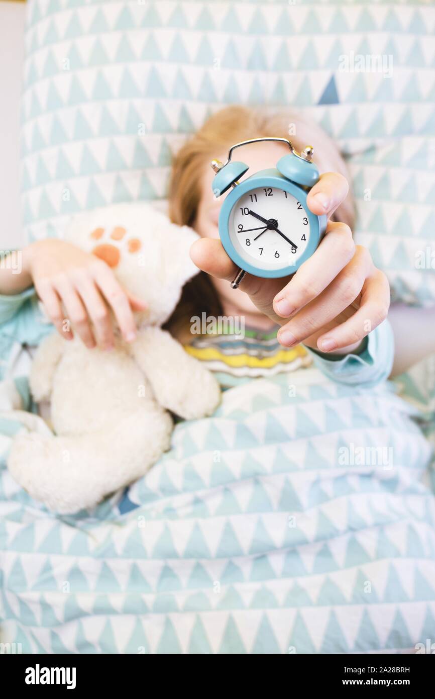 alarm clock disturbing a sleeping little girl that is defocused Stock ...