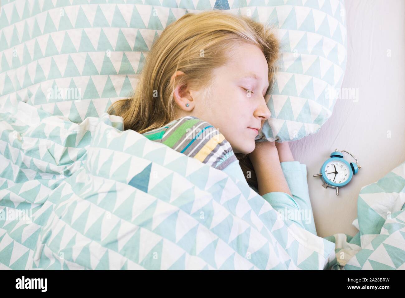 alarm clock disturbing a sleeping little girl that is defocused Stock ...