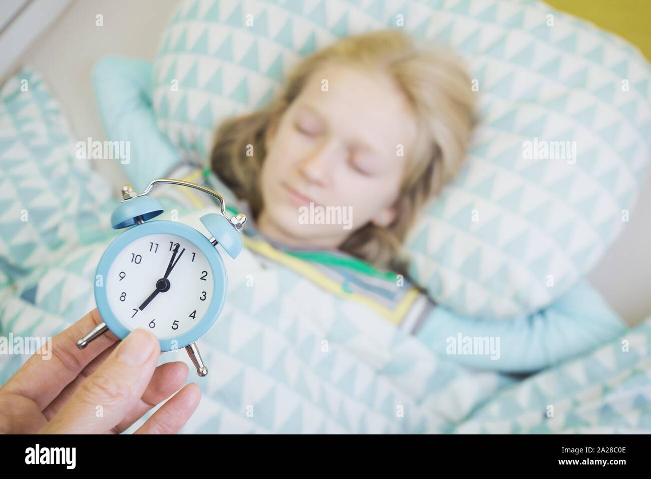 alarm clock disturbing a sleeping little girl that is defocused Stock ...