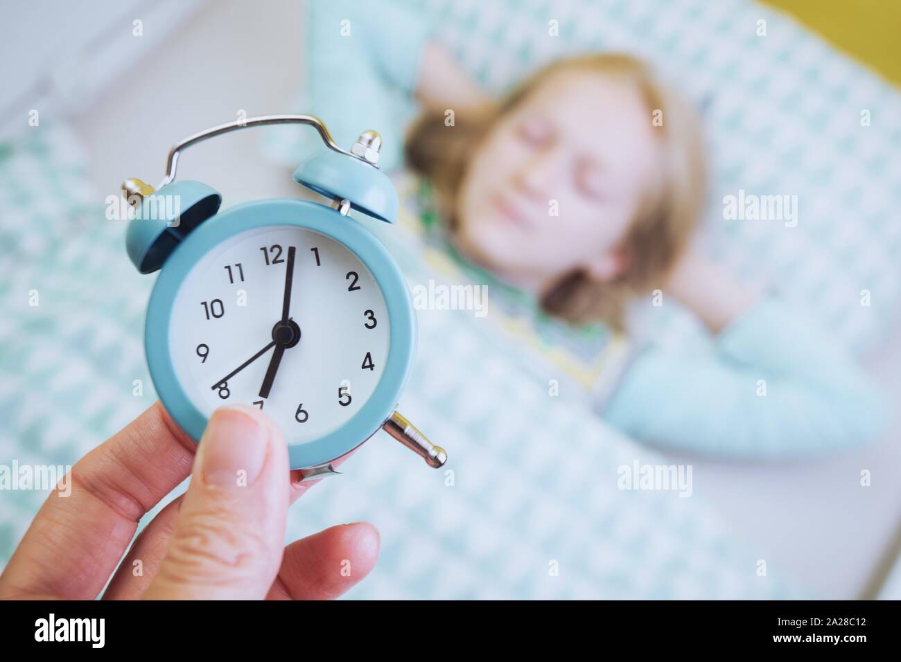 alarm clock disturbing a sleeping little girl that is defocused Stock ...