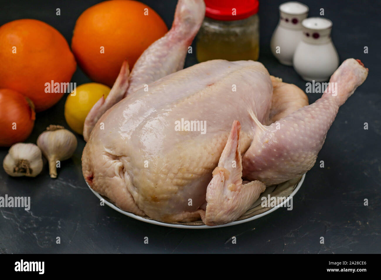 Raw Chicken prepares for baking in the oven with honey, oranges, lemons ...