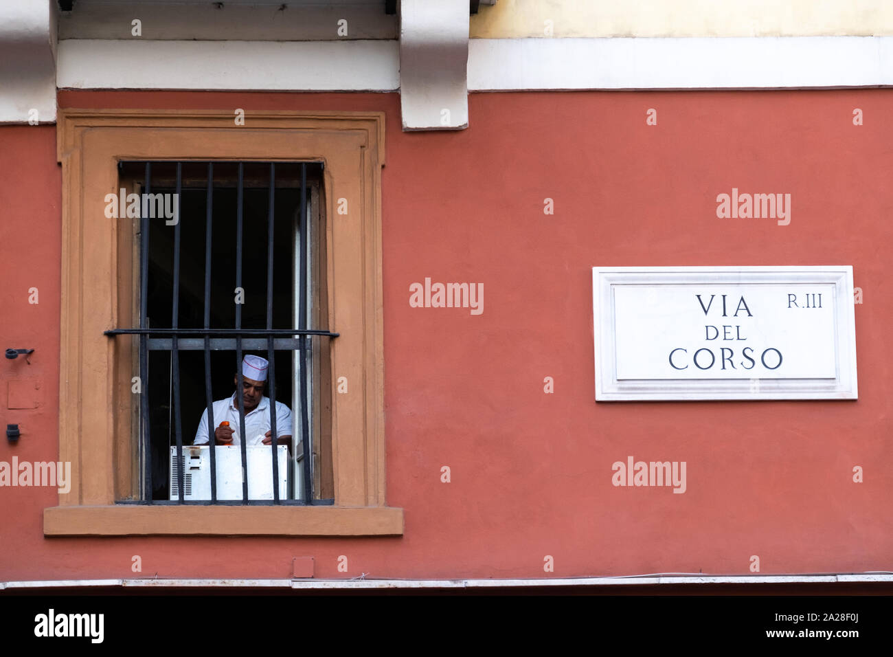 Chef in traditional chef's hat and whites. He is working behind bars of ...