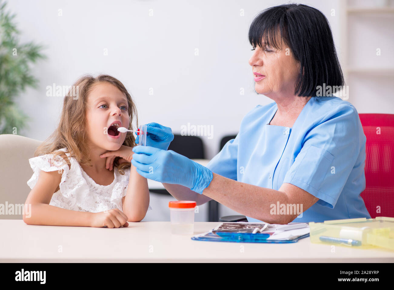 The little girl visiting old female doctor Stock Photo - Alamy