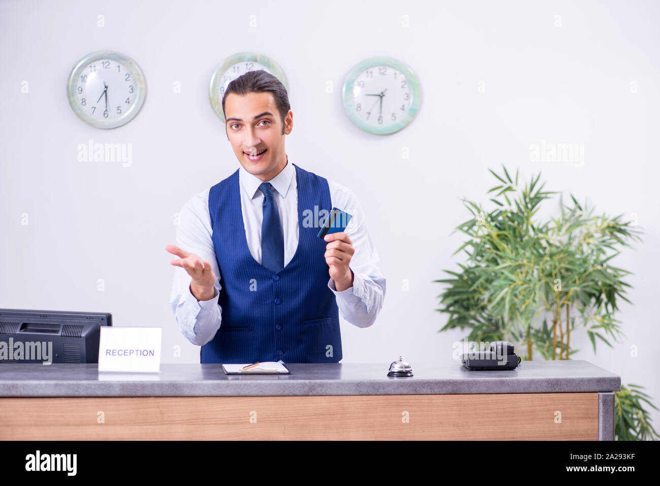 The young man receptionist at the hotel counter Stock Photo - Alamy