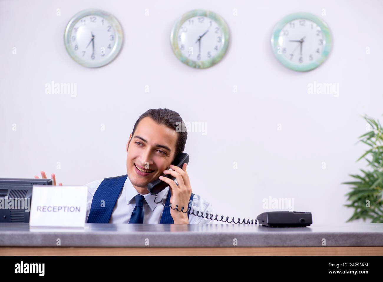 The young man receptionist at the hotel counter Stock Photo - Alamy