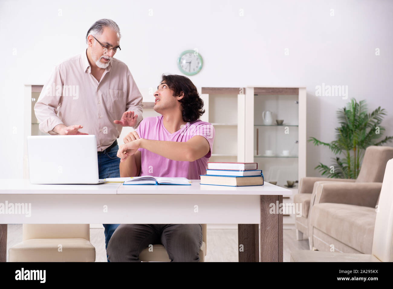 The old father helping his son in exam preparation Stock Photo - Alamy