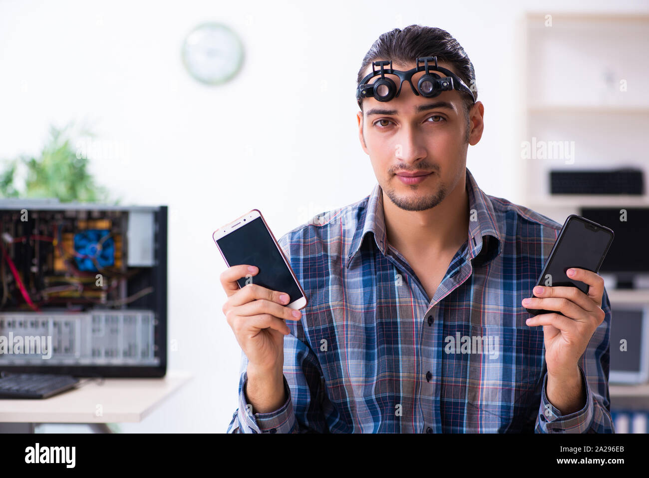 The young handsome technician repairing mobile phone Stock Photo - Alamy