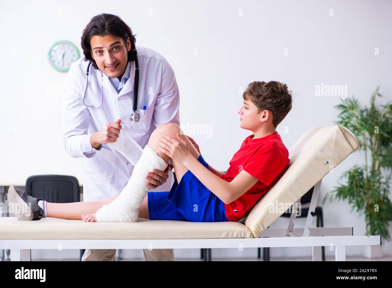The leg injured boy visiting young doctor traumatologist Stock Photo ...