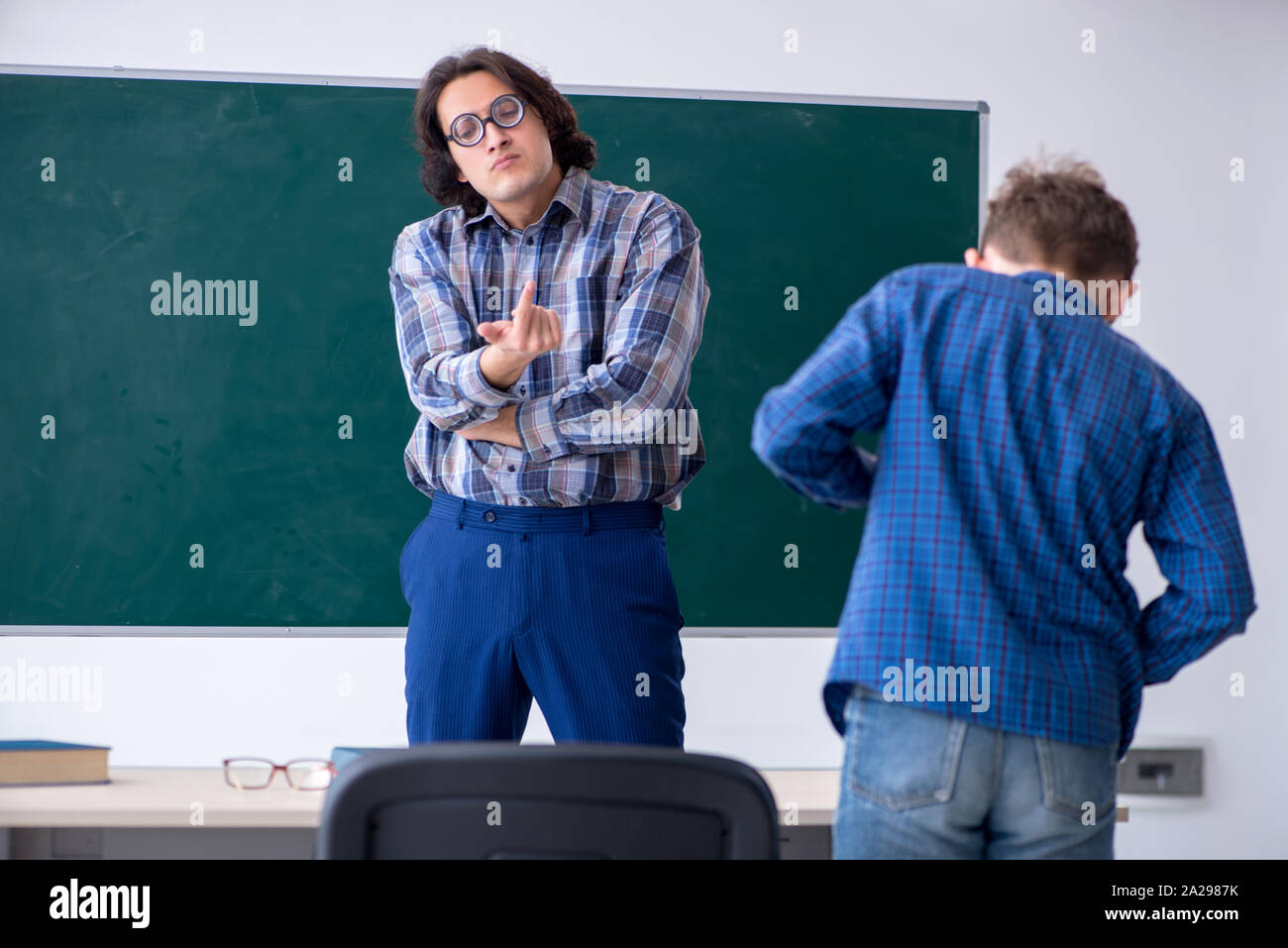 The funny male teacher and boy in the classroom Stock Photo - Alamy