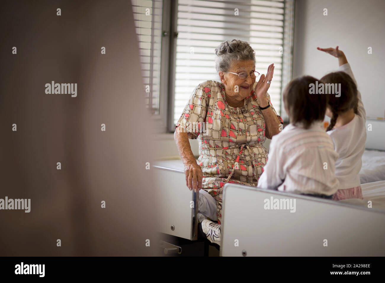 View of an old lady playing with her grandchildren Stock Photo - Alamy