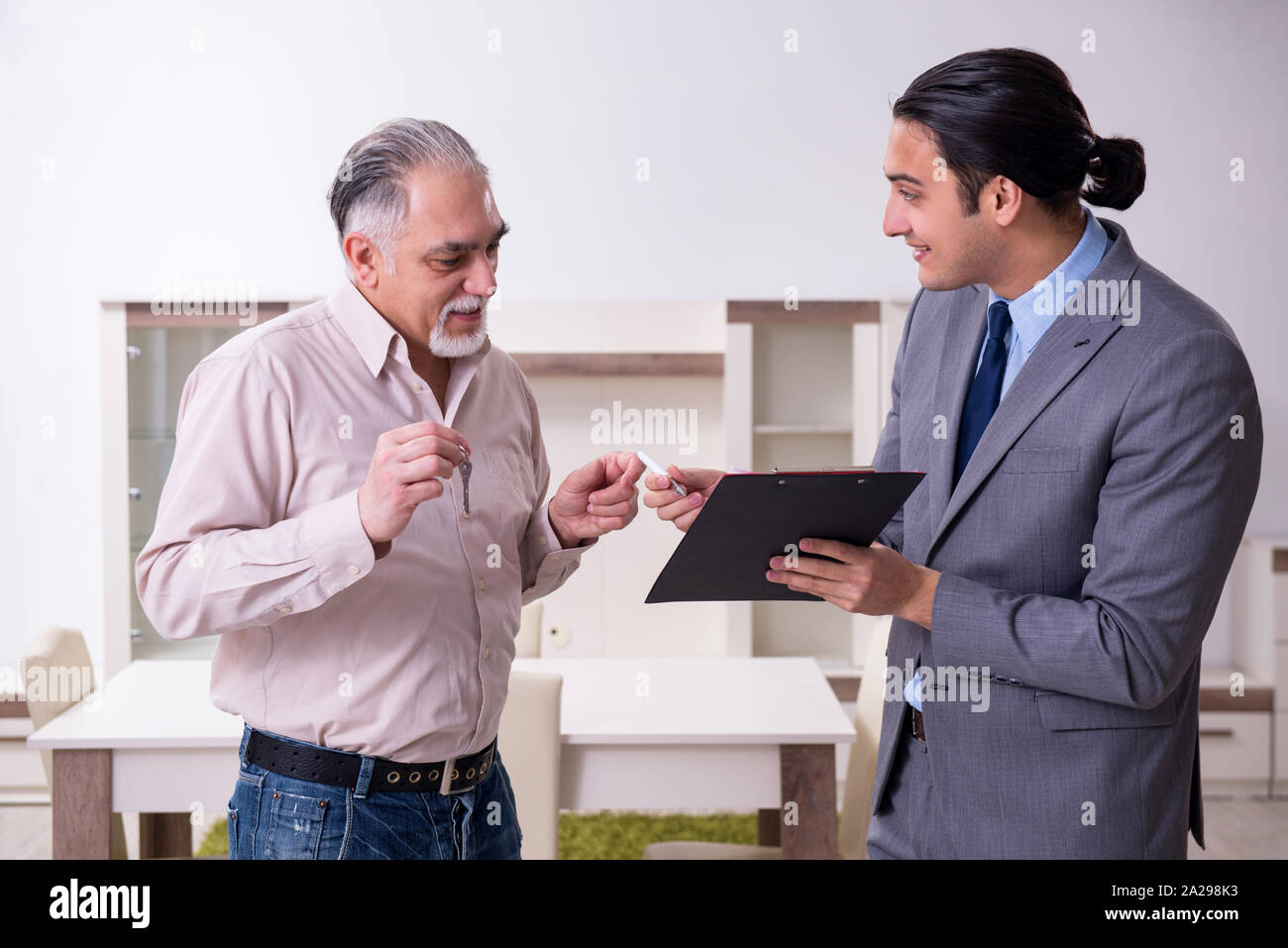 The male real estate agent and male client in the apartment Stock Photo ...