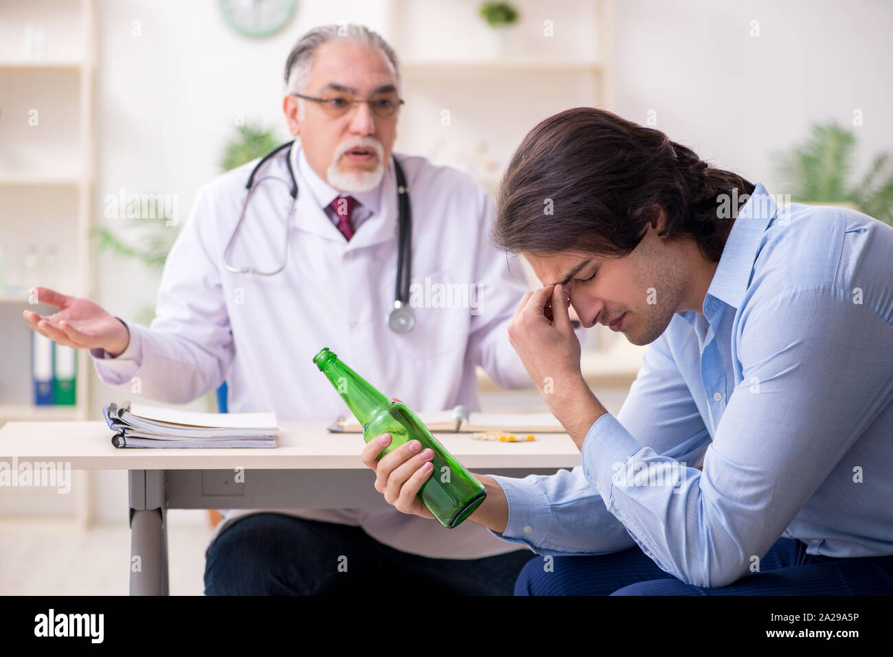 The young male alcoholic visiting old doctor Stock Photo - Alamy