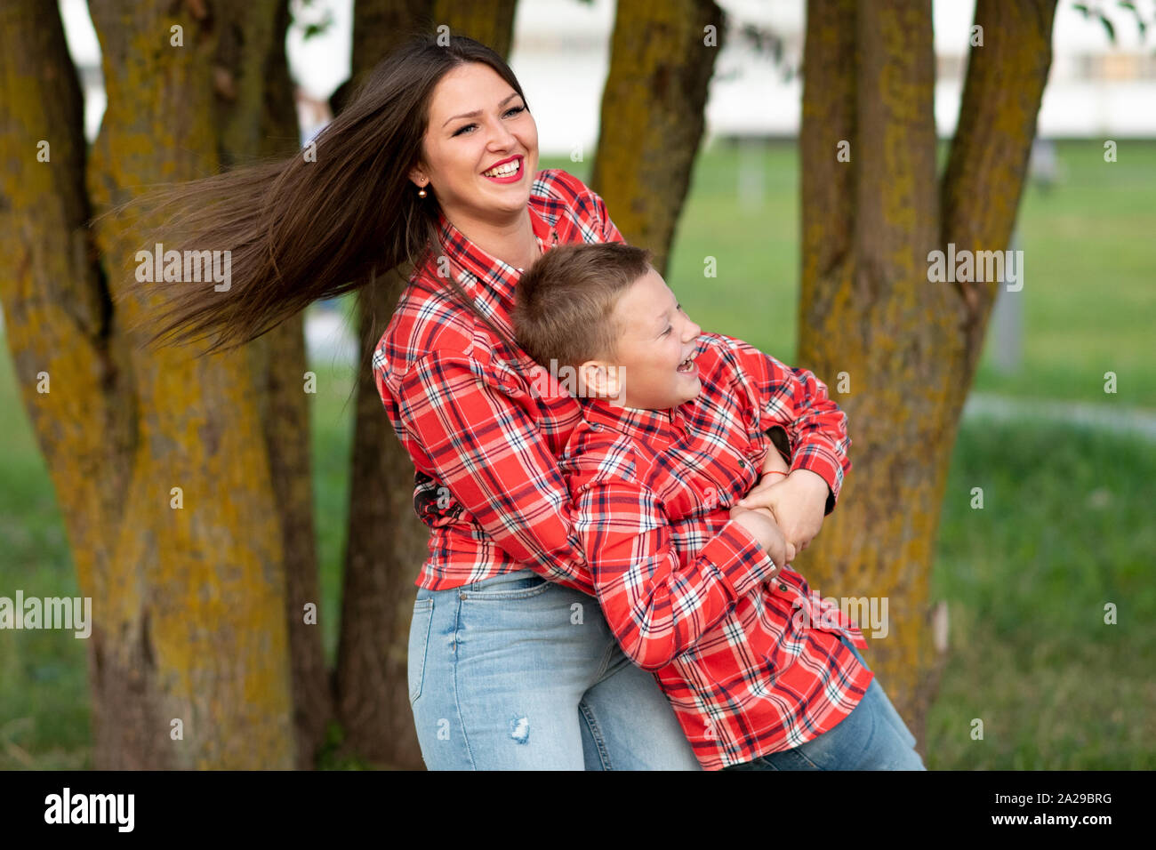 Mom, laughing cheerfully, circling her son, holding him in her arms Stock Photo - Alamy
