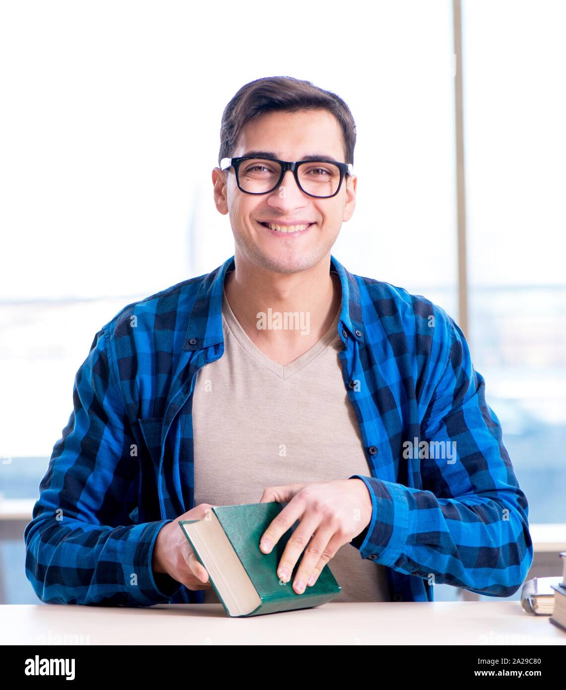 Student studying in the empty library with book preparing for exam ...