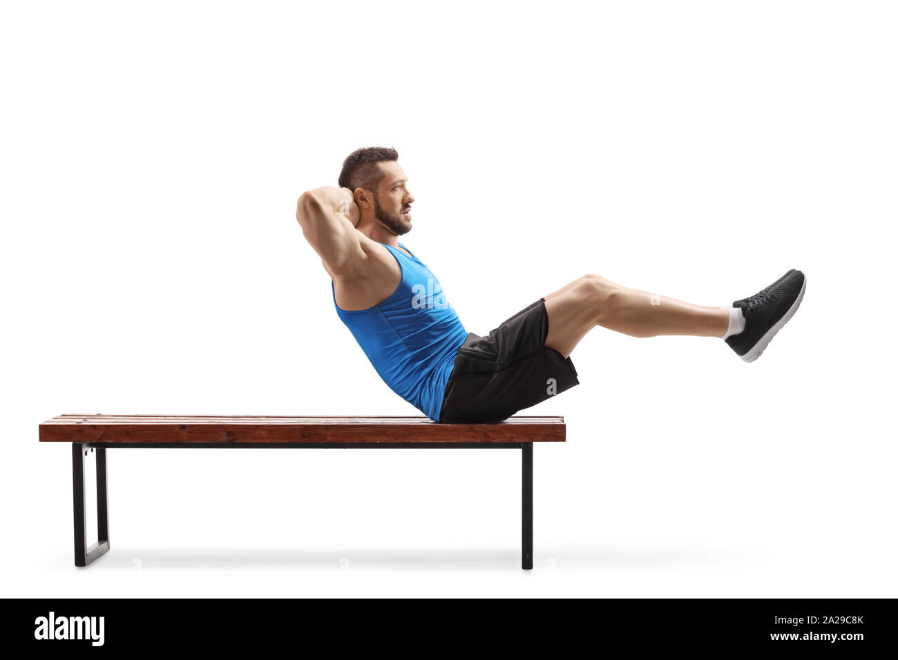 Full length profile shot of a fit young man exercising abs on a bench ...