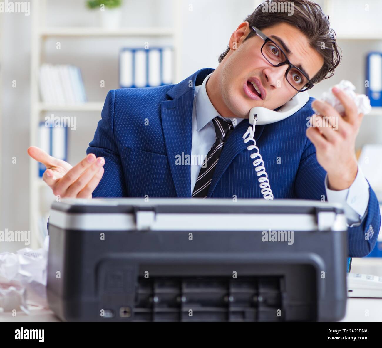 The businessman angry at copying machine jamming papers Stock Photo - Alamy