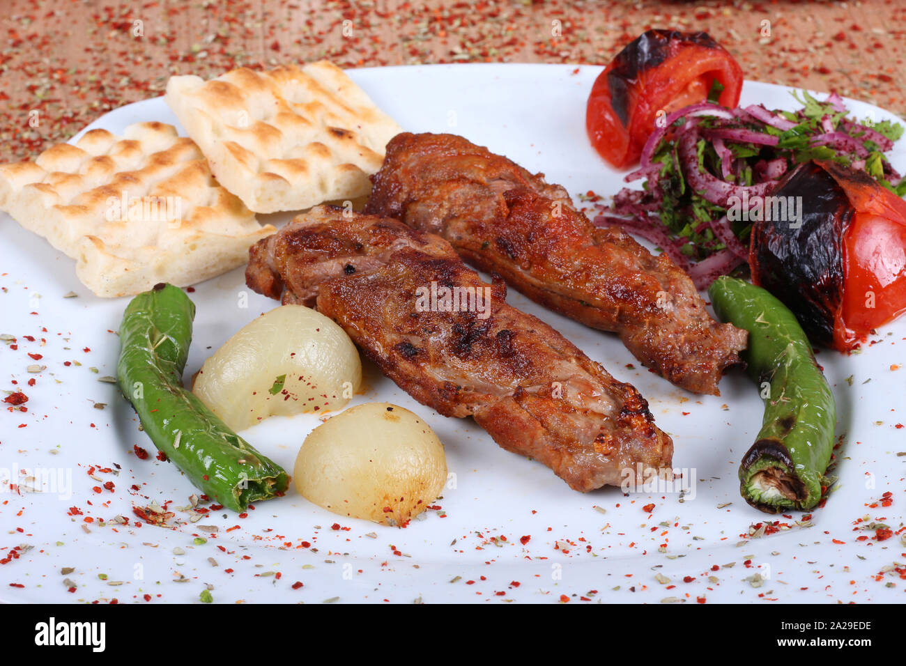 Turkish beef barbecue and fresh vegetables on a wooden table filled ...