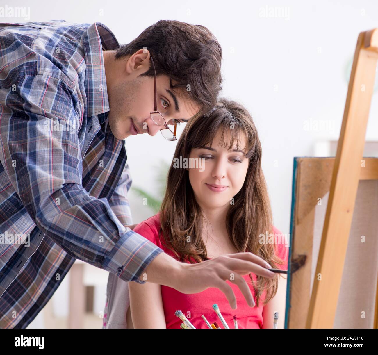 The artist coaching student in painting class in studio Stock Photo - Alamy