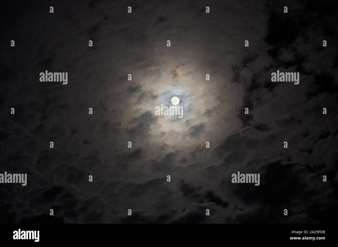 Full moon behind clouds Stock Photo - Alamy