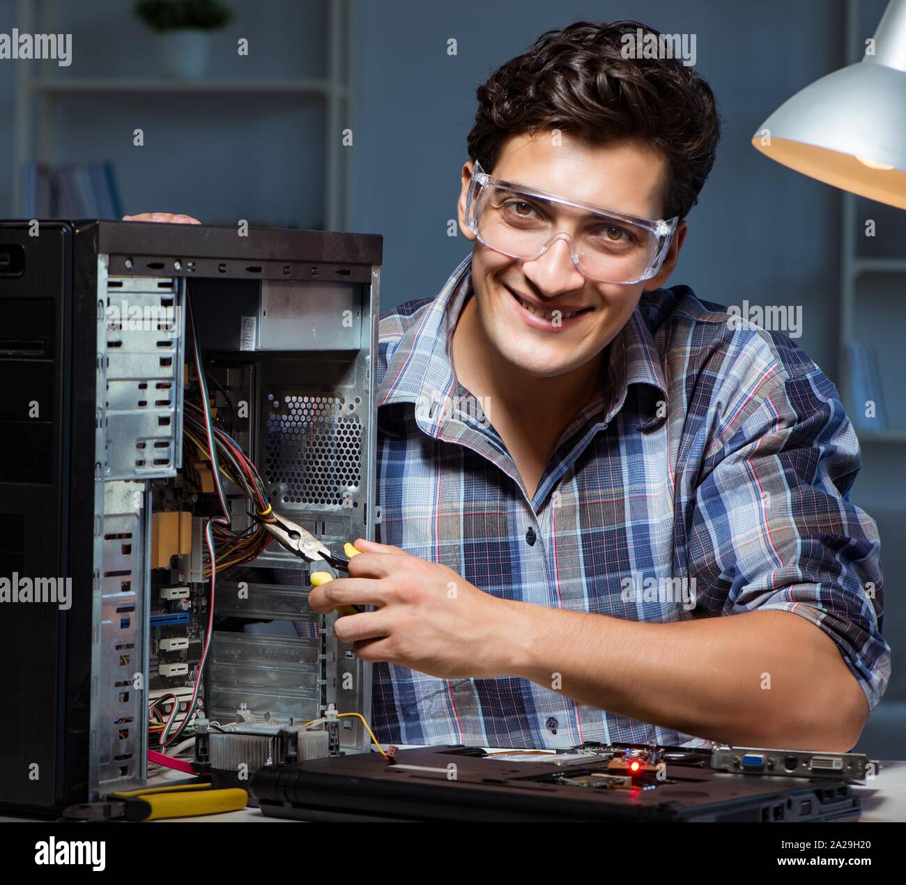 The man repairing computer desktop with pliers Stock Photo - Alamy