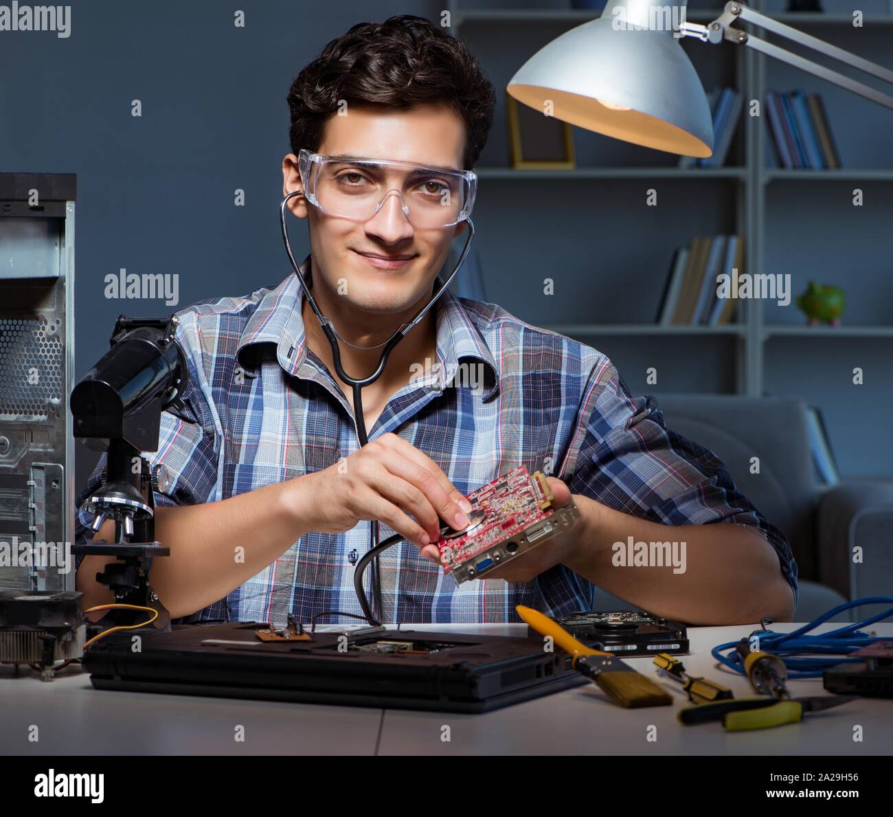The computer repair concept with man inspecting with stethoscope Stock ...