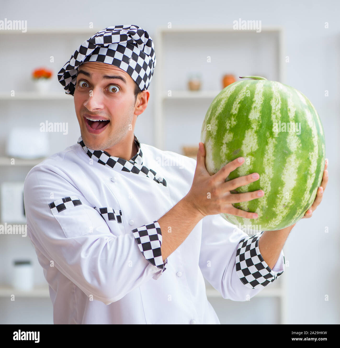 The male cook with watermelon in kitchen Stock Photo - Alamy