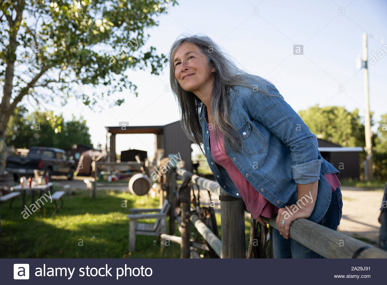 Woman looking over fence hi-res stock photography and images - Alamy