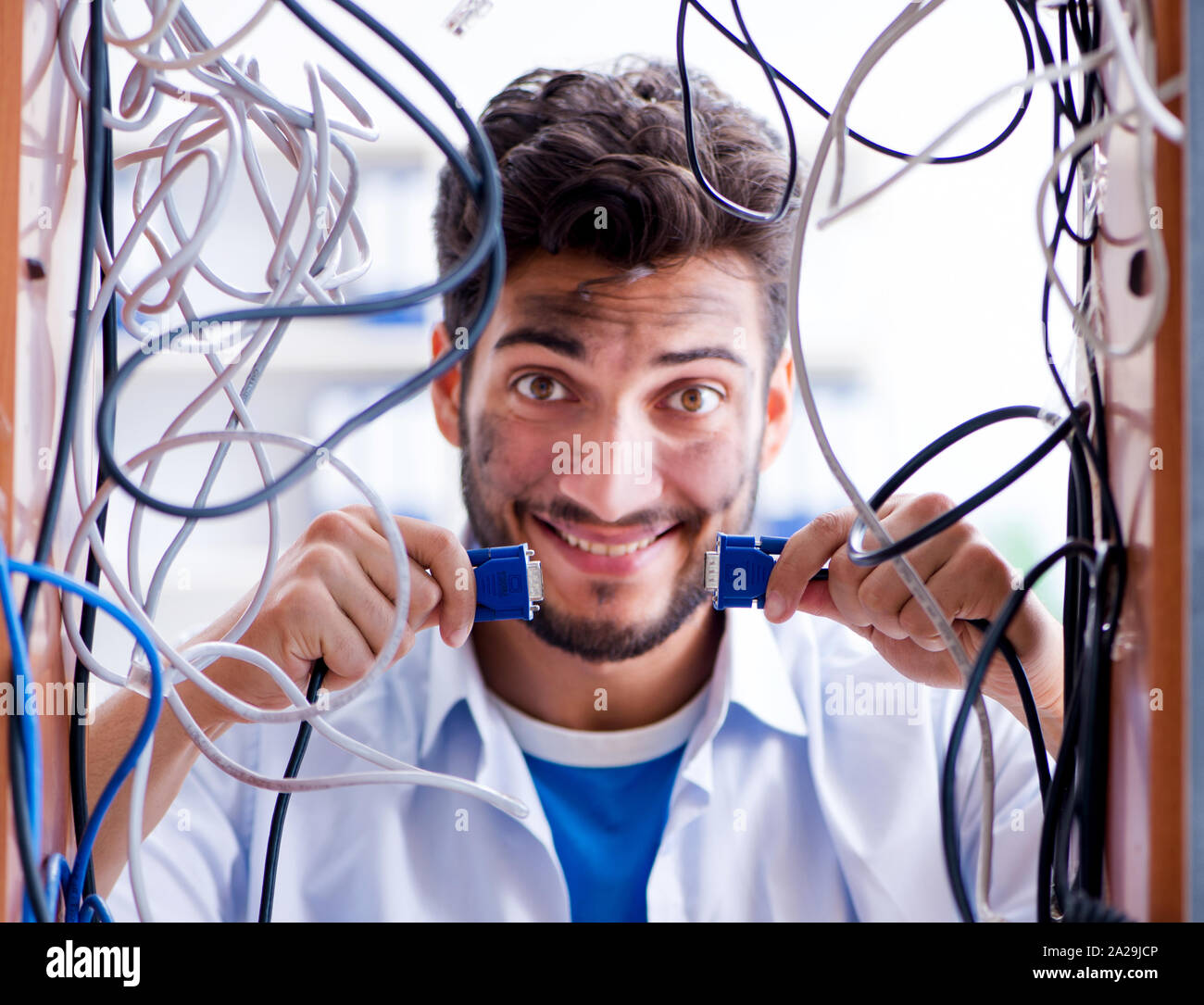 The electrician trying to untangle wires in repair concept Stock Photo ...
