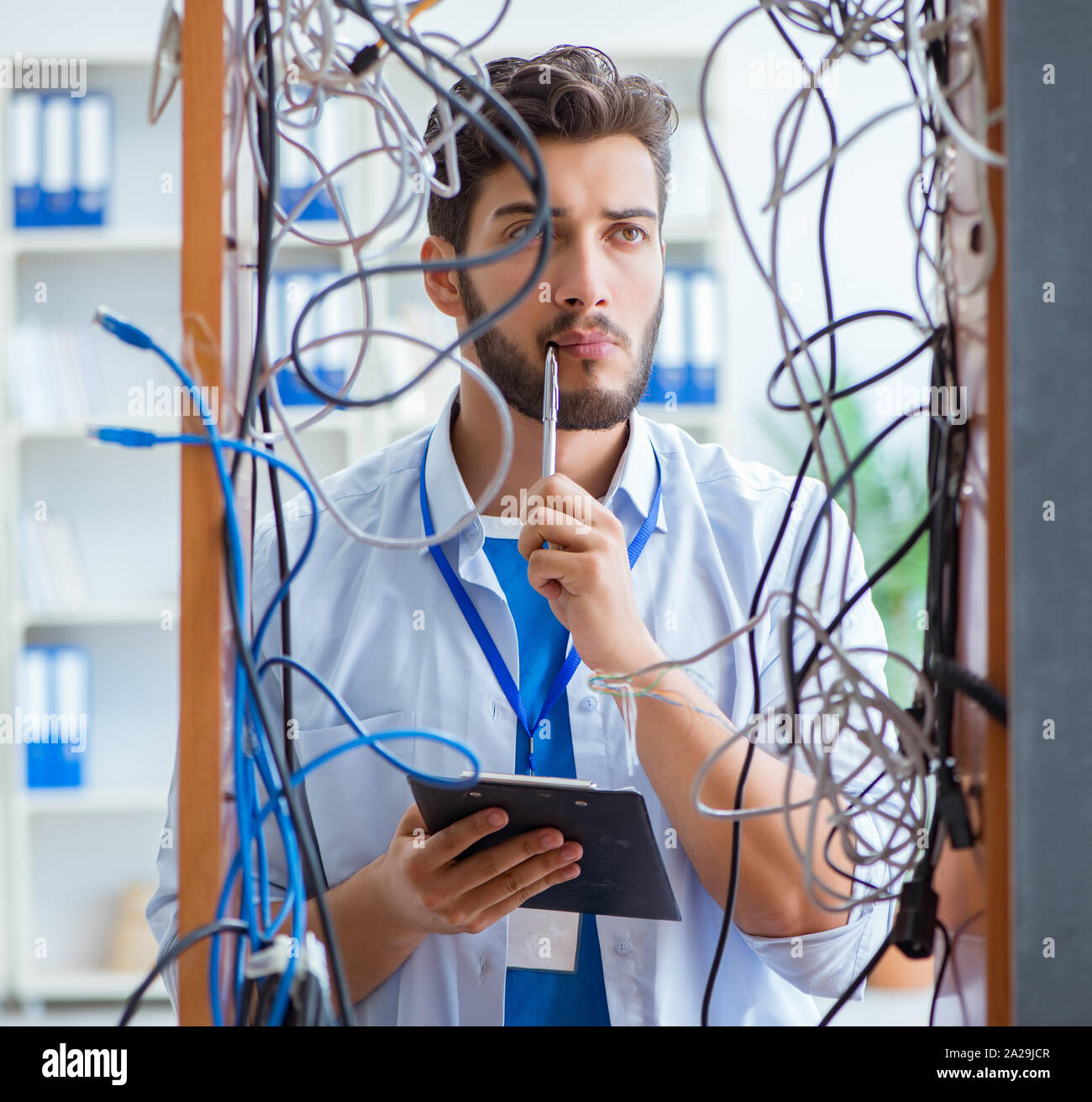 The electrician trying to untangle wires in repair concept Stock Photo ...