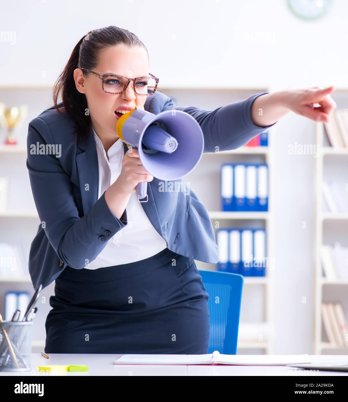 The angry businesswoman yelling with loudspeaker in office Stock Photo ...