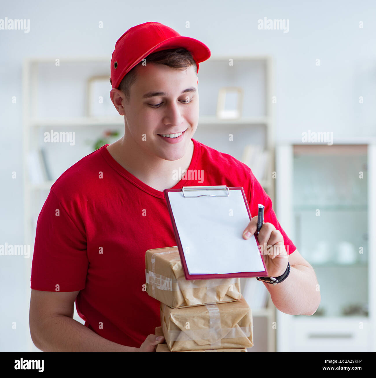 The post man delivering a parcel package Stock Photo - Alamy