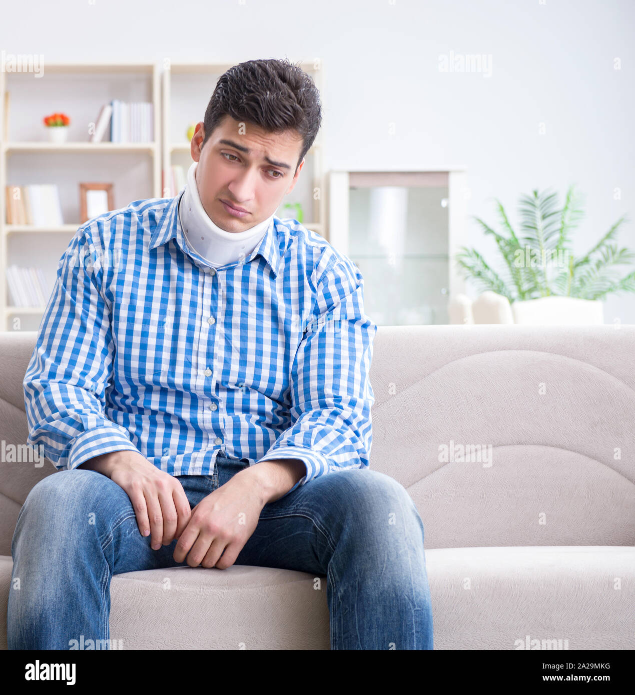 Young man suffering a neck spine head trauma wearing a cervical collar ...