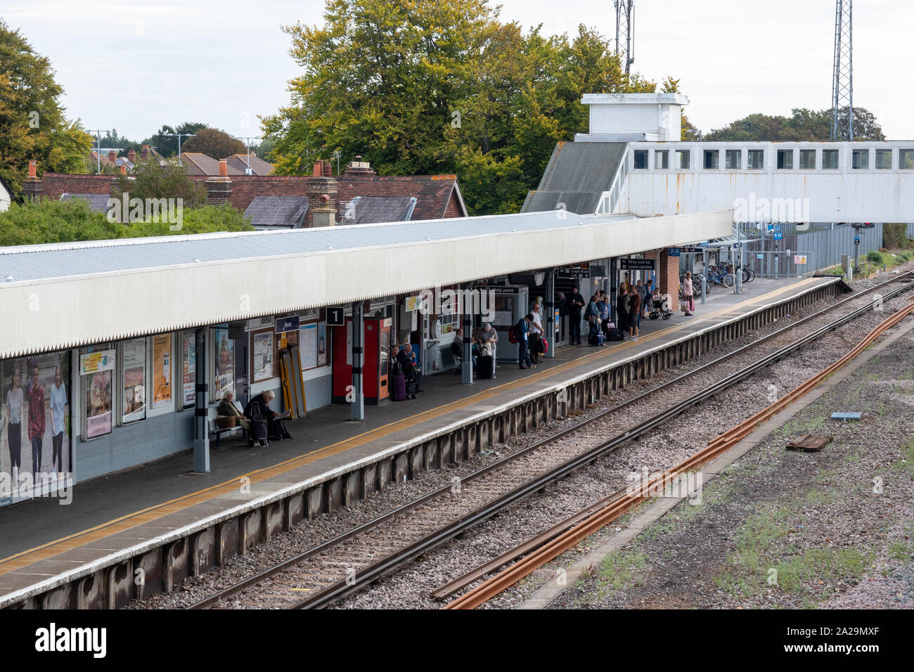 Railway passengers waiting for a train on a platform Stock Photo - Alamy