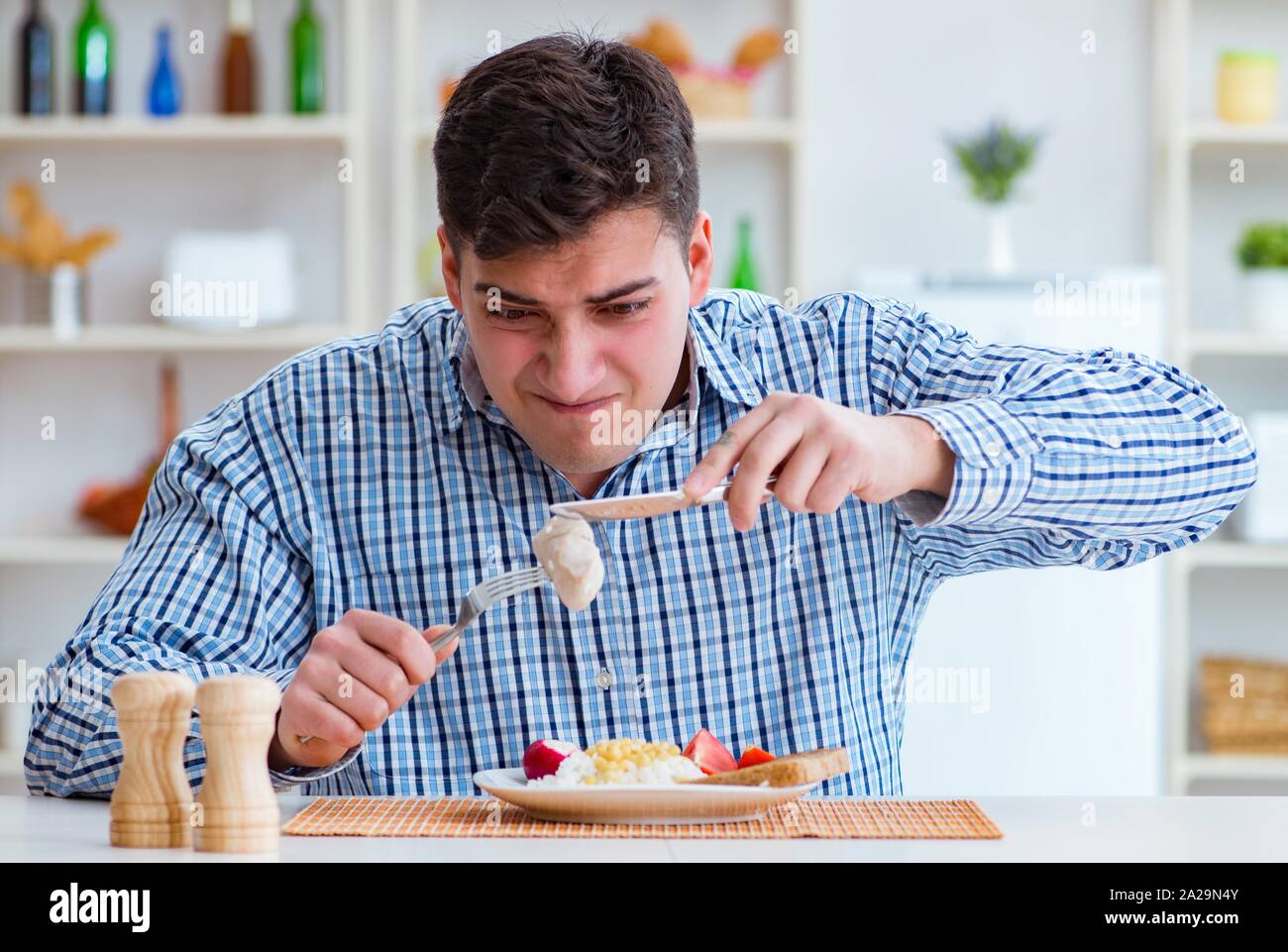 The man eating tasteless food at home for lunch Stock Photo - Alamy