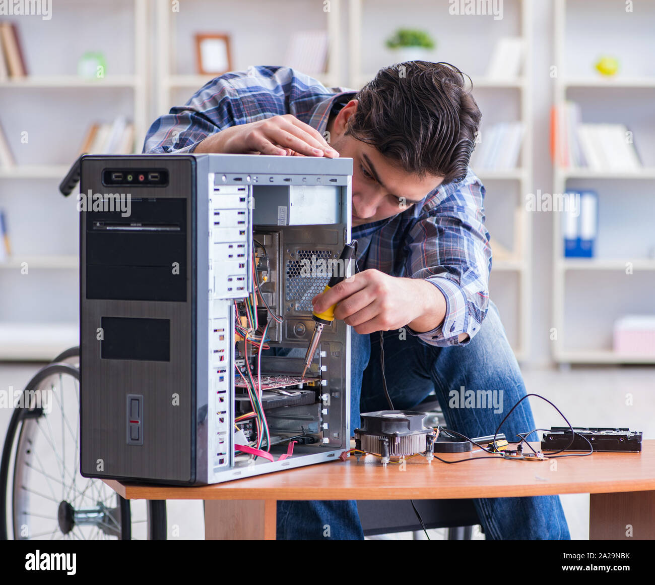 The computer repairman on wheelchair working Stock Photo - Alamy