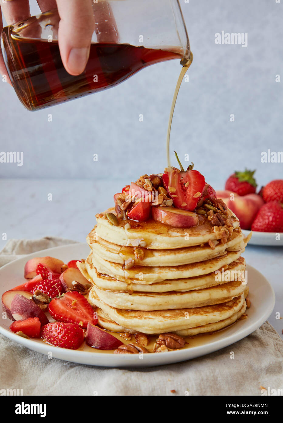 Pouring Maple Syrup Over A Stack of American Pancakes with Stawberries ...