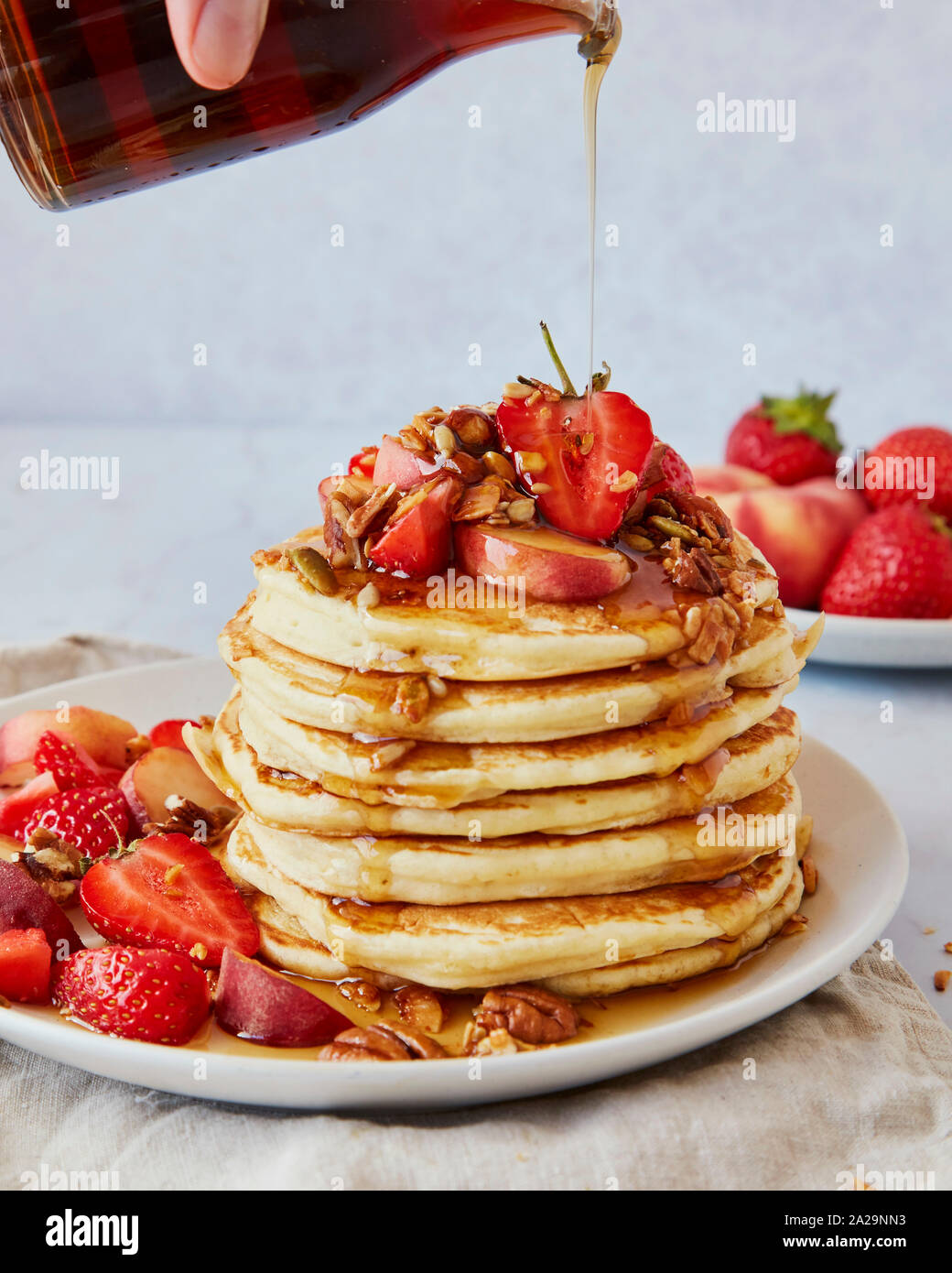 Pouring Maple Syrup Over A Stack of American Pancakes with Stawberries ...