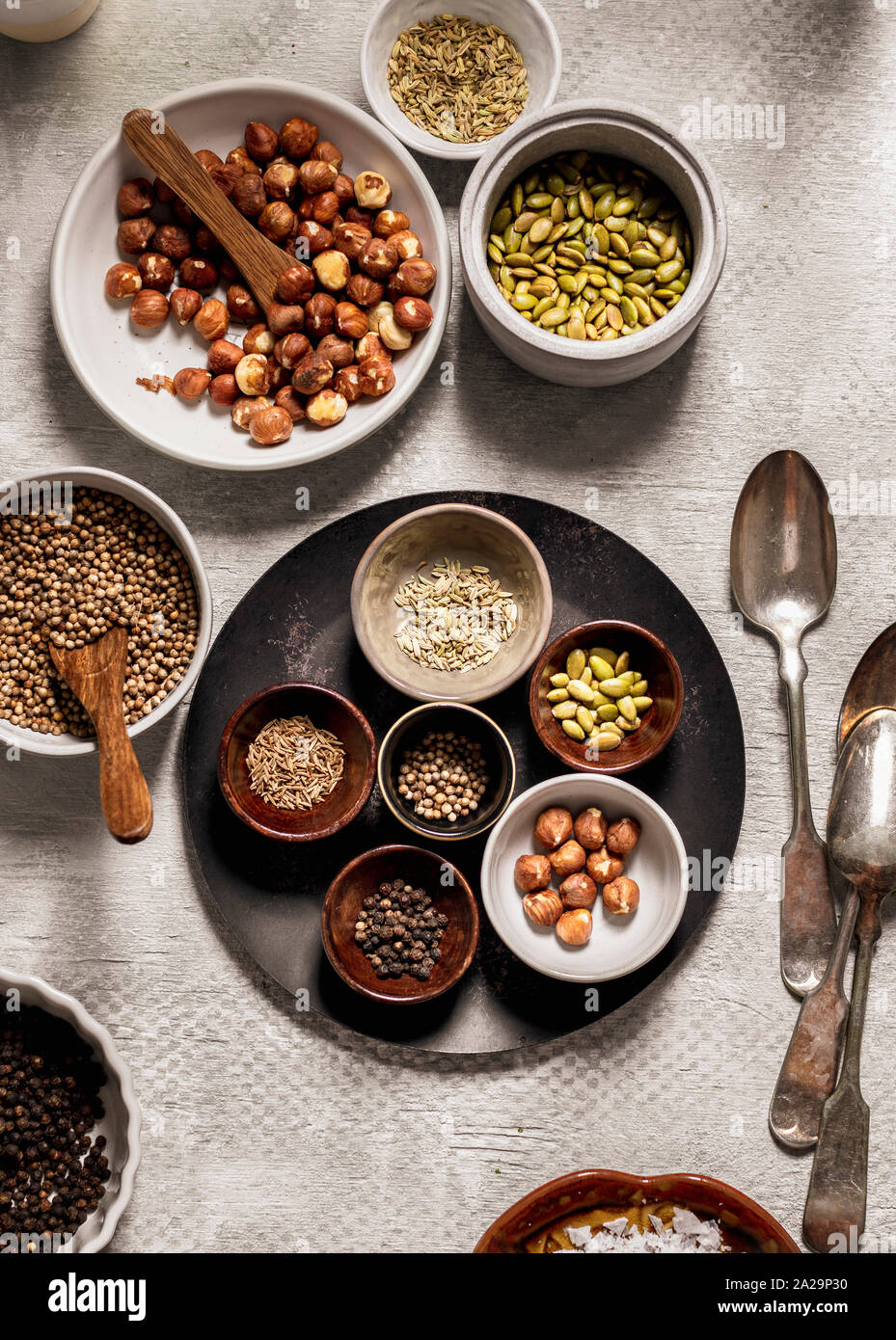 Assortment of spices, seeds and nuts in bowls on gray background Stock ...